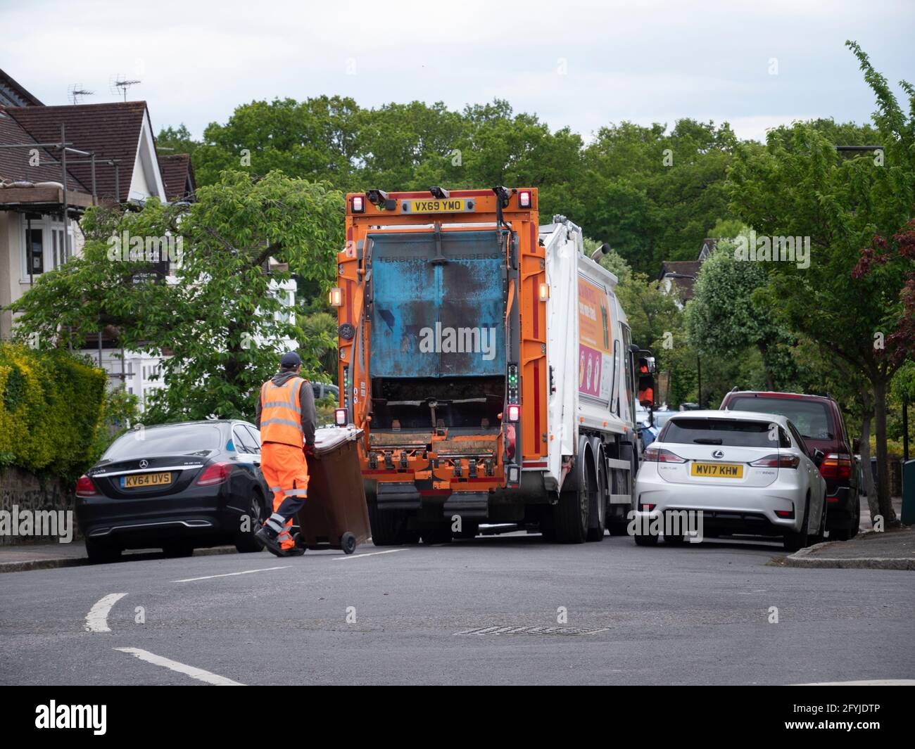 garbage refuse collectors emptying wheelie bin trash into Terberg ...