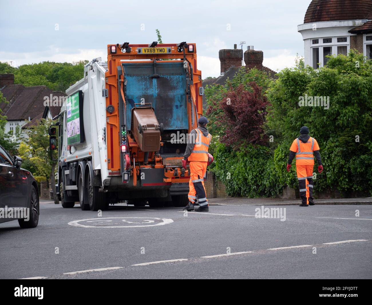 garbage refuse collectors emptying wheelie bin trash into Terberg ...