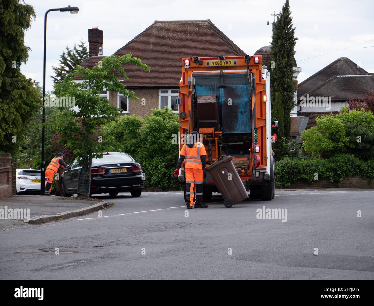 garbage refuse collectors emptying wheelie bin trash into Terberg ...
