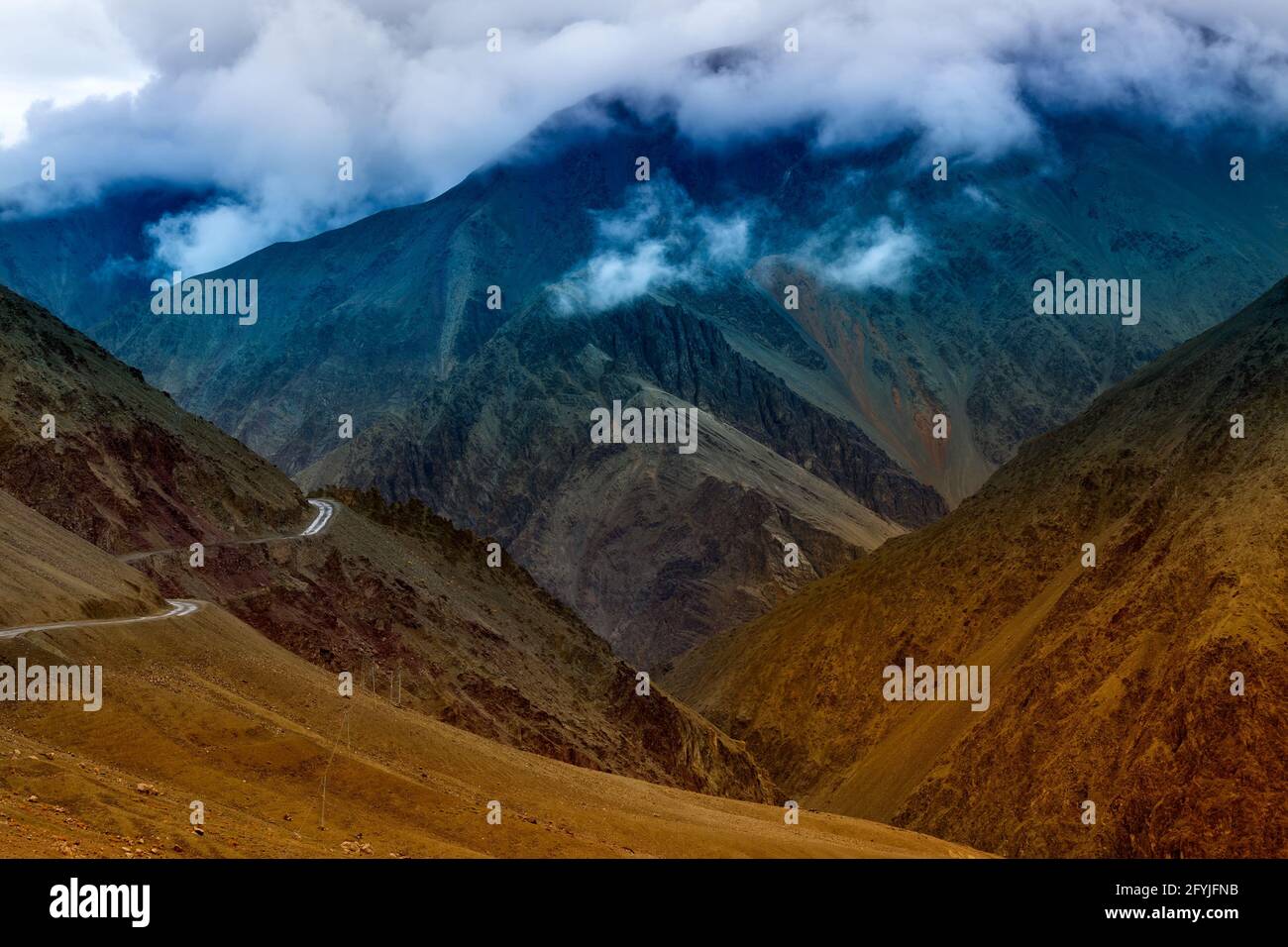 Clouds embracing a mountain peak over highway of Zojila Pass, a high ...