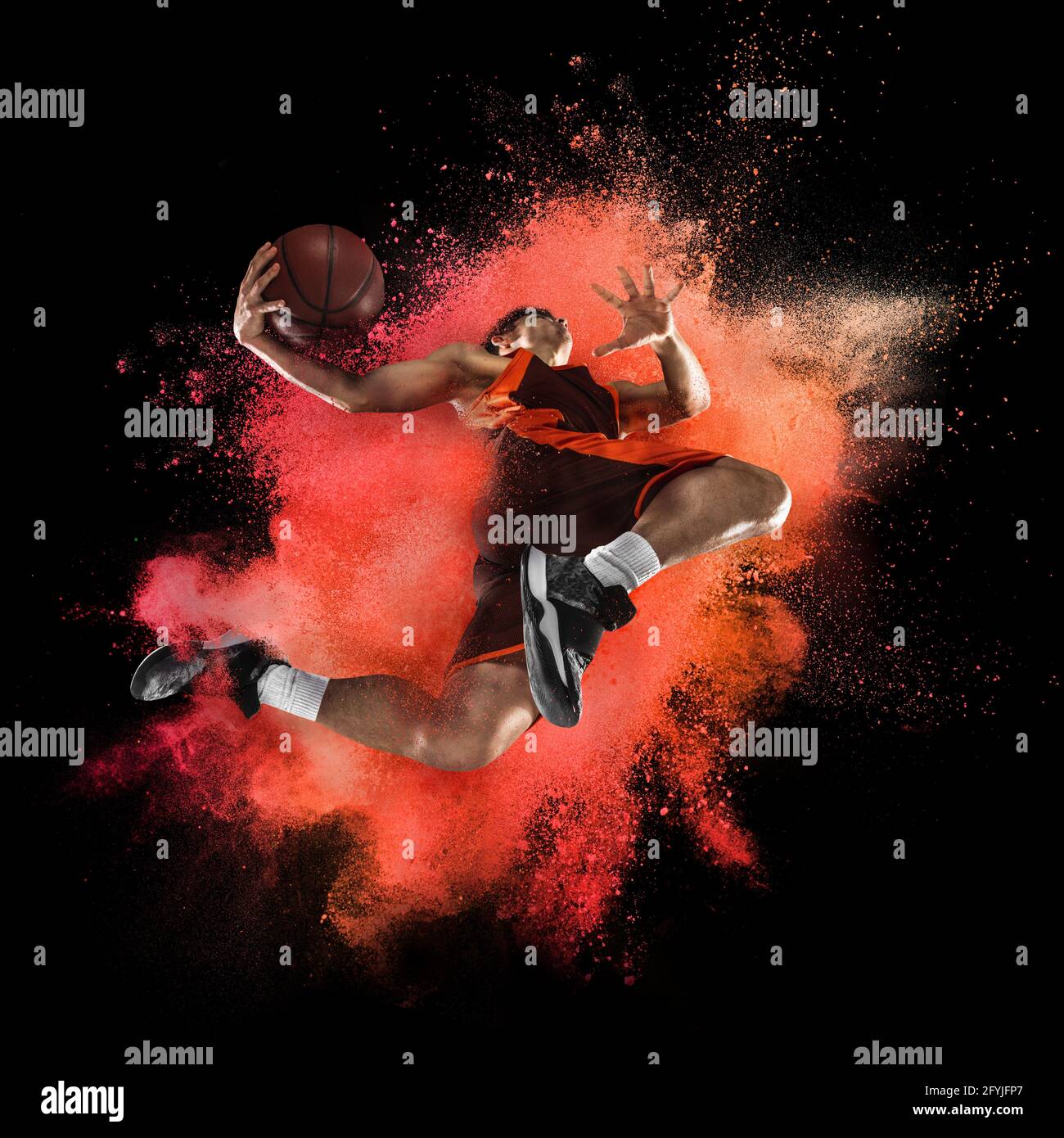 One young sportsman basketball player in explosion of colored neon ...