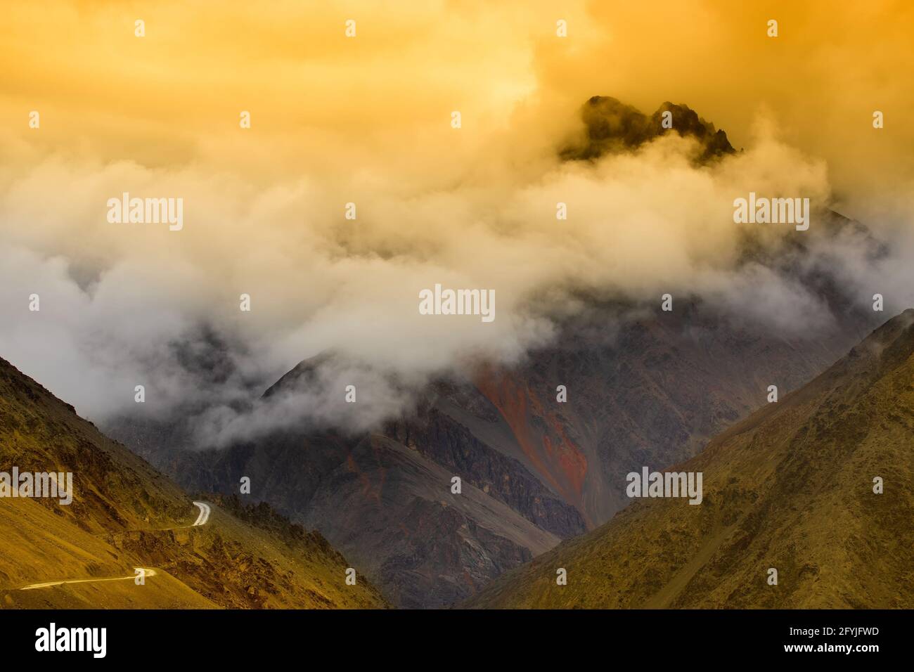 Clouds embracing a mountain peak over highway of Zojila Pass, a high ...