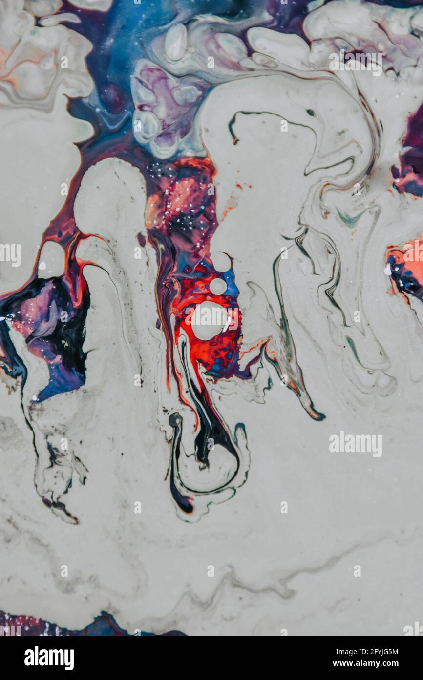A vertical shot of an abstract painting with mixed white oil paint ...