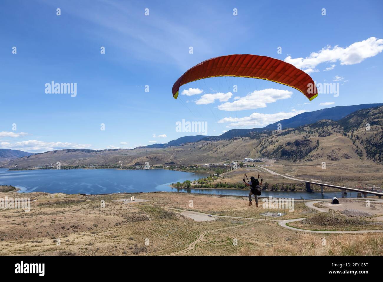 Adventurous Man Flying on a Paraglider around the mountains Stock Photo ...