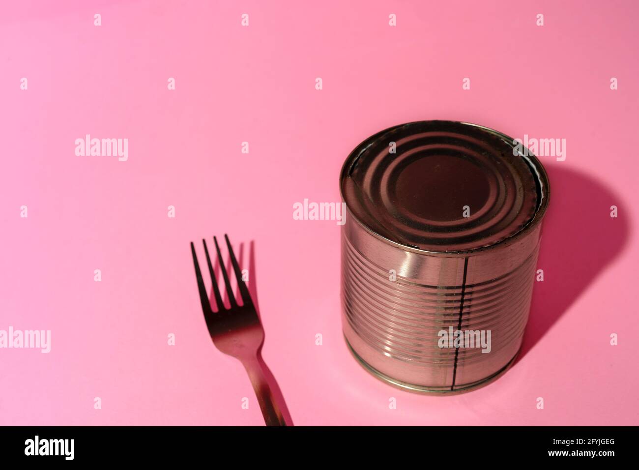Canned food tin on pink studio background Stock Photo - Alamy