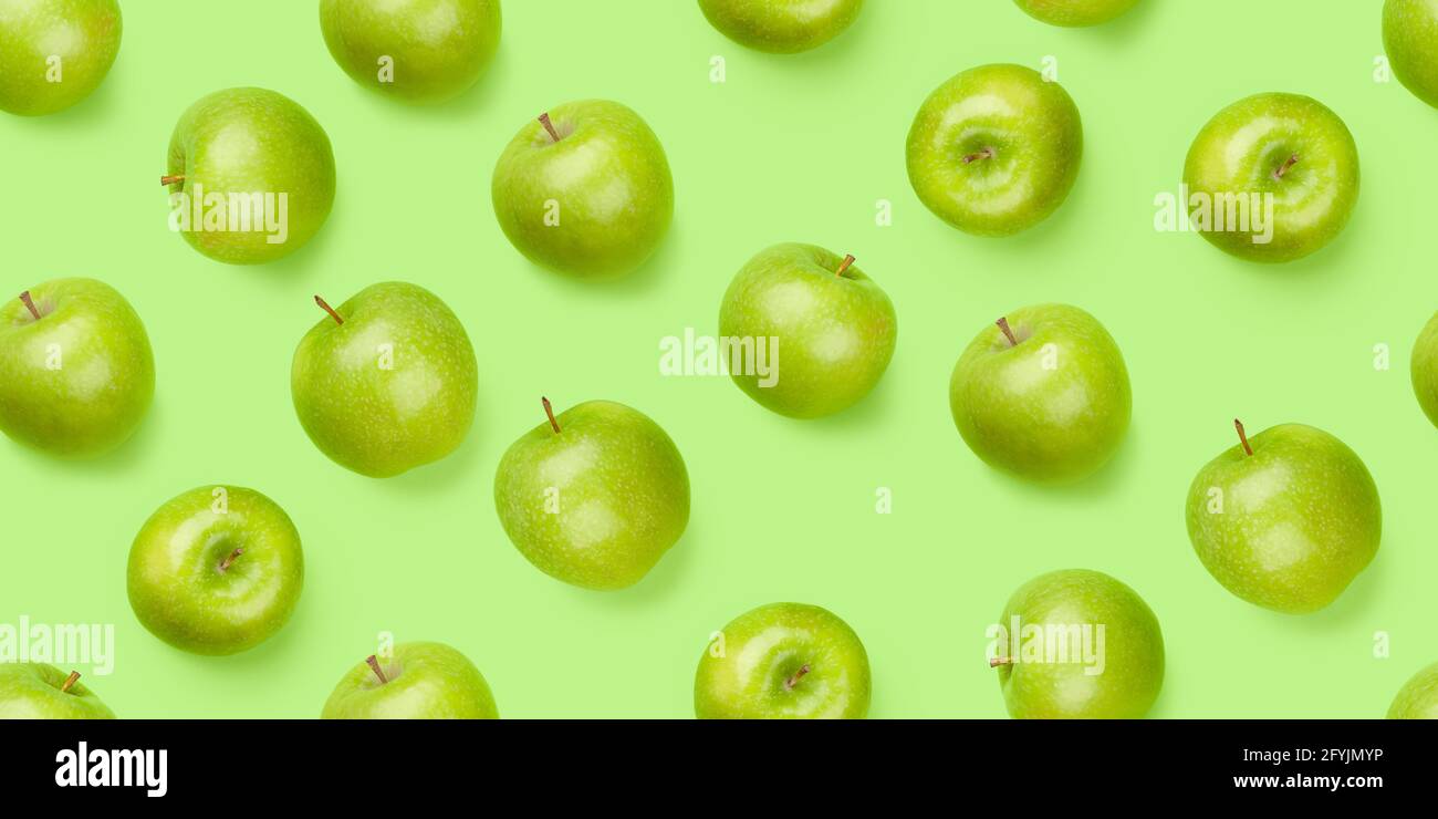 Green apple fruits over green backdrop seamless texture. Flat lay ...