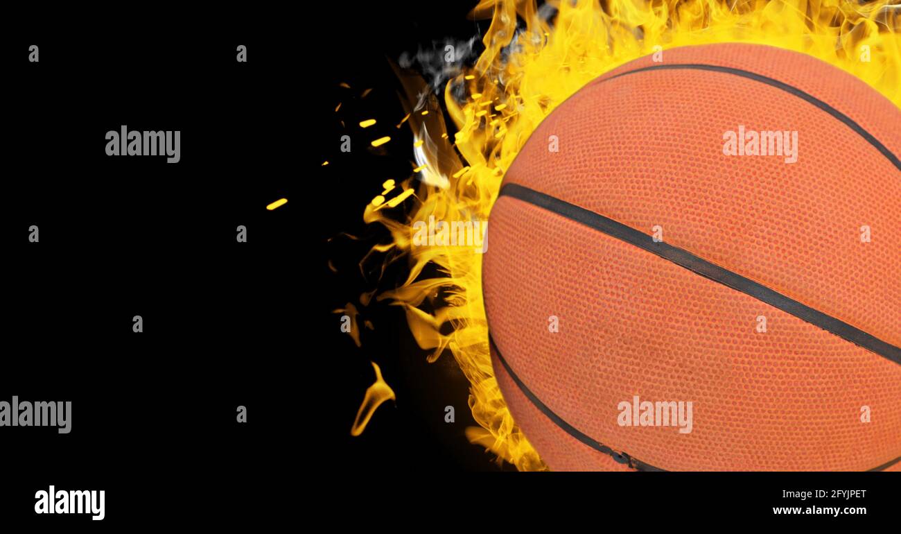 Composition of basketball on fire over black background with copy space ...