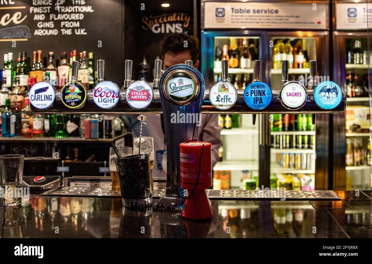 A bartender preparing drink for customer seen inside a bar in soho area ...