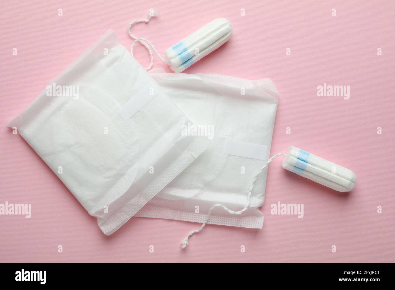 Sanitary pads and tampons on pink background Stock Photo - Alamy