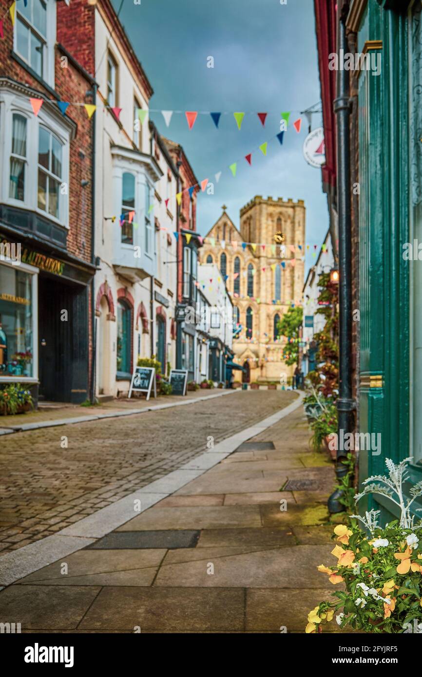 Ripon cathedral as seen from the street leading to it with shops and ...