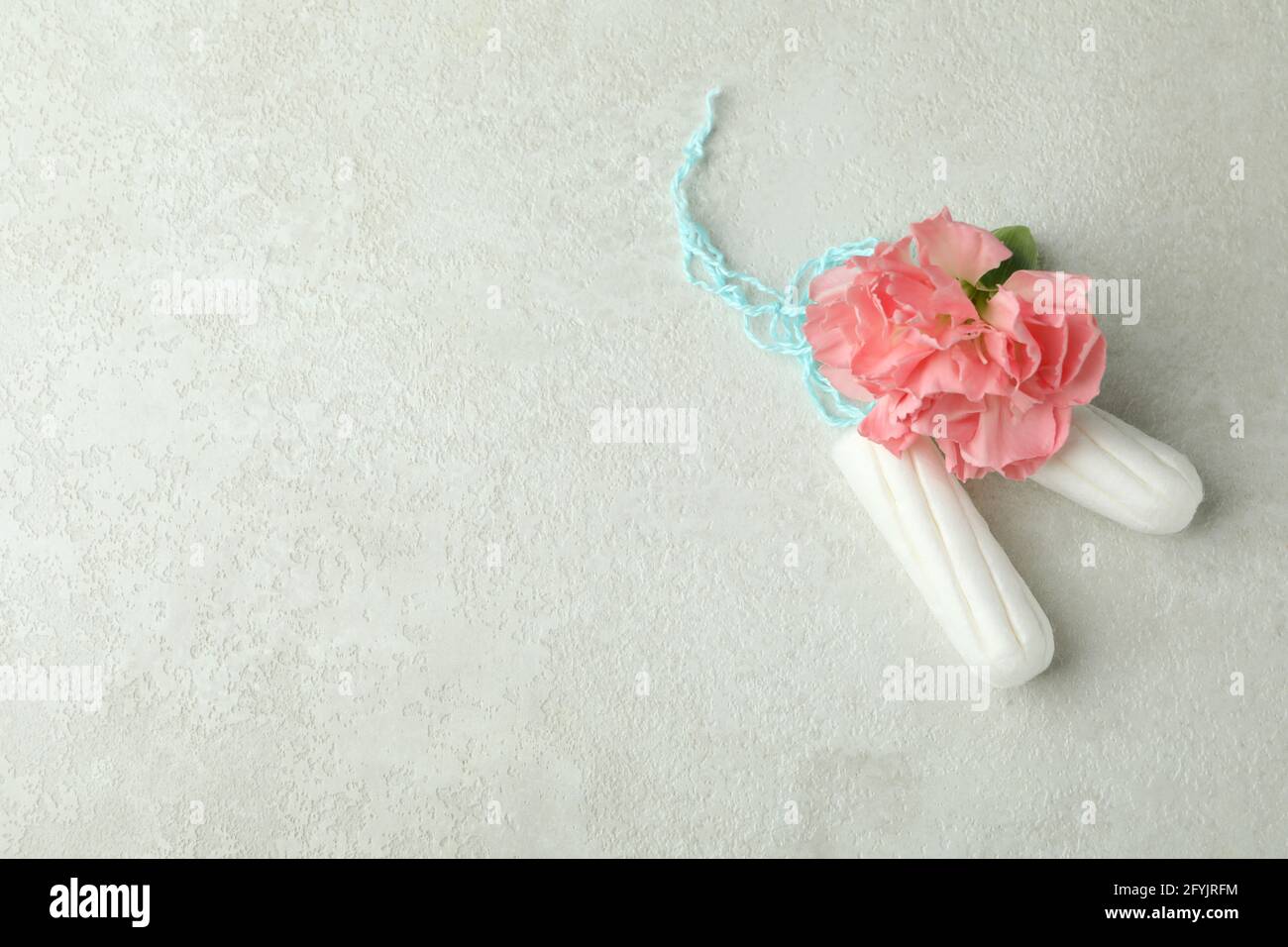 Tampons and flower on white textured background Stock Photo - Alamy