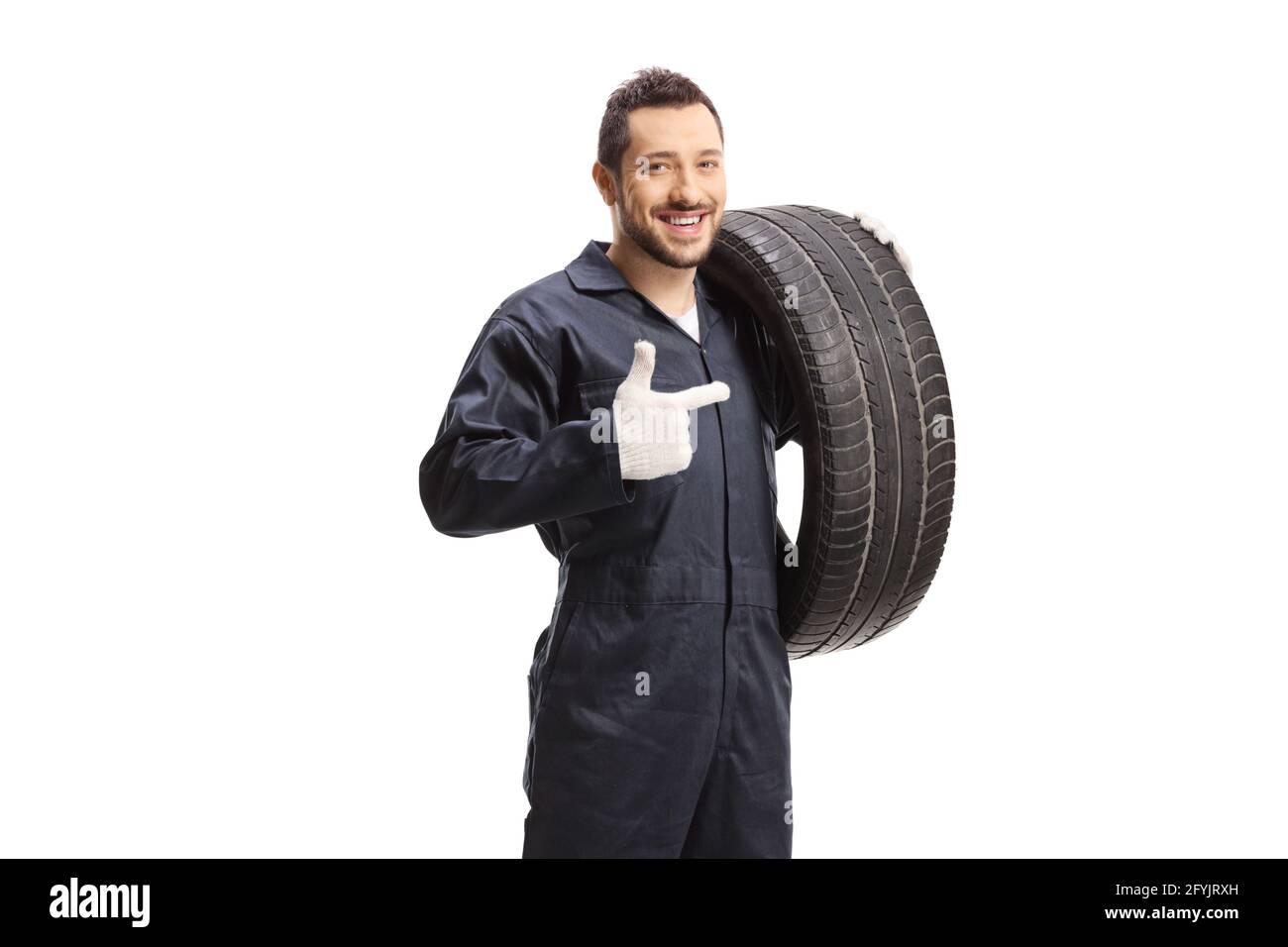 Auto mechanic holding a of car tire and pointing isolated on white ...