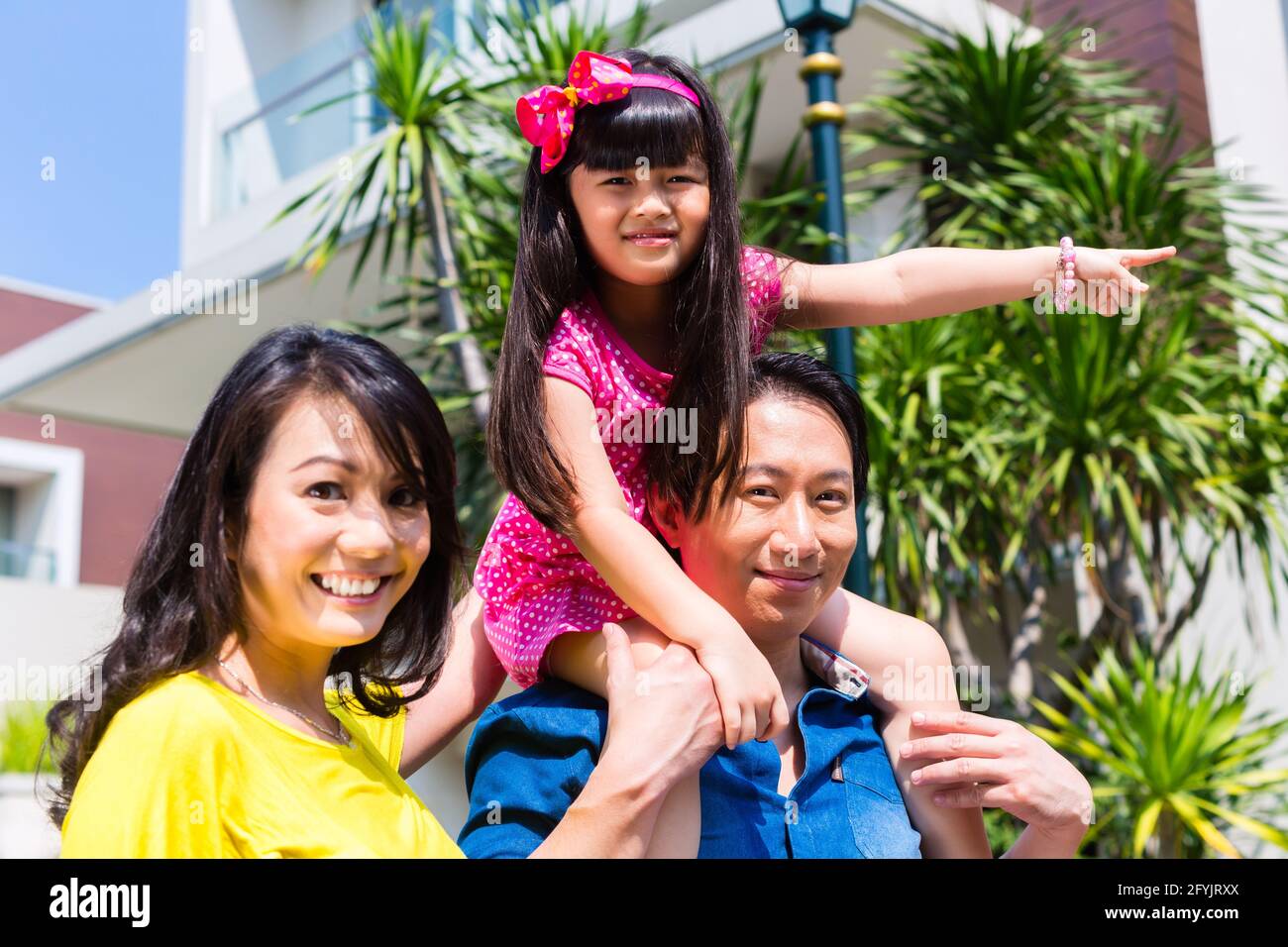 Asian Chinese family of parents and child standing proud in front of ...