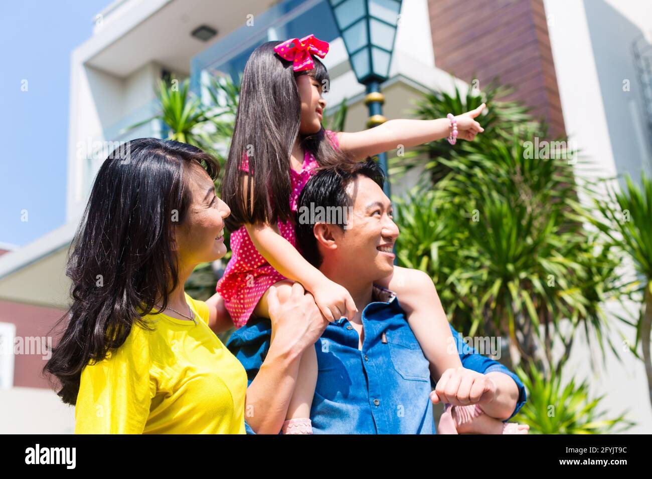 Asian Chinese family of parents and child standing proud in front of ...