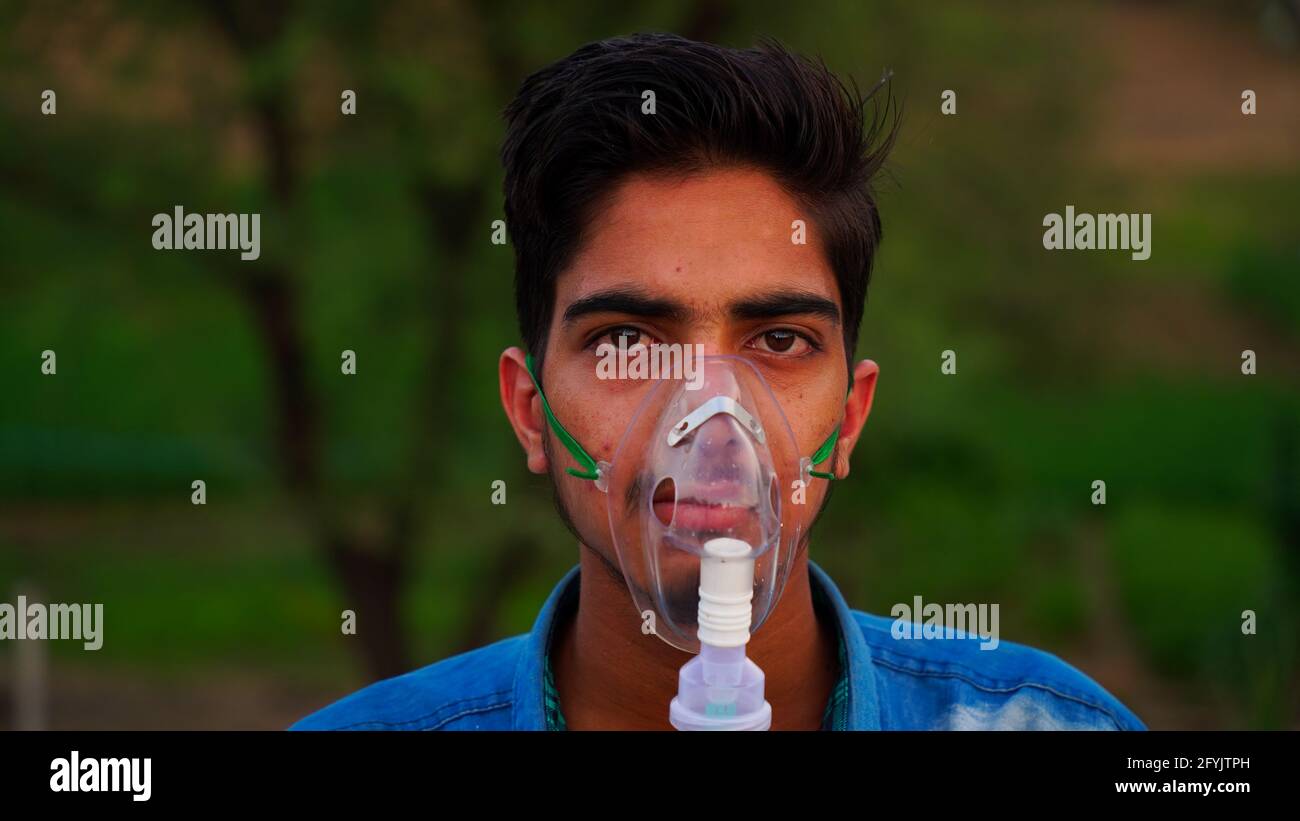 Young Man wearing oxygen mask at the home alone. A Coronavirus infected ...