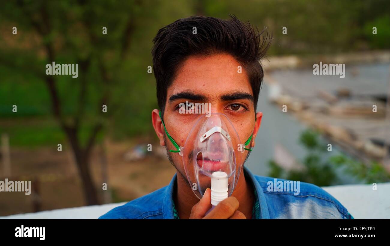 Young Man wearing oxygen mask at the home in India. A Coronavirus ...