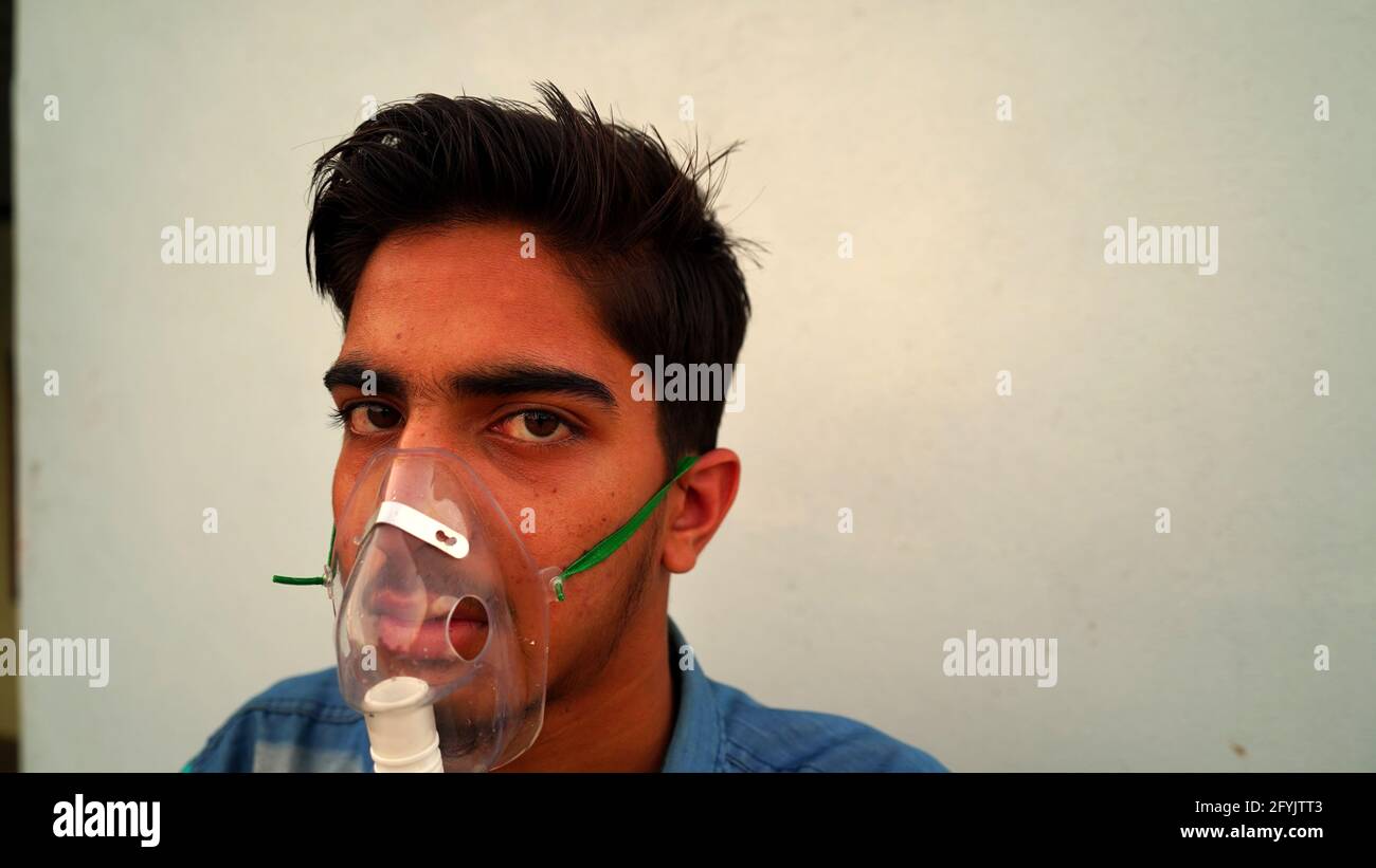 Young Man wearing oxygen mask at the home alone. A Coronavirus infected ...
