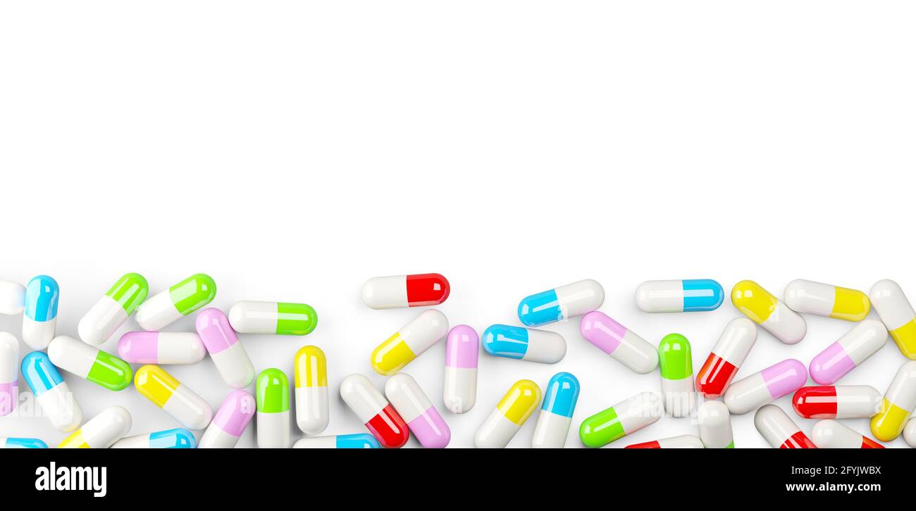 Different colored pill capsules border edge over white background ...
