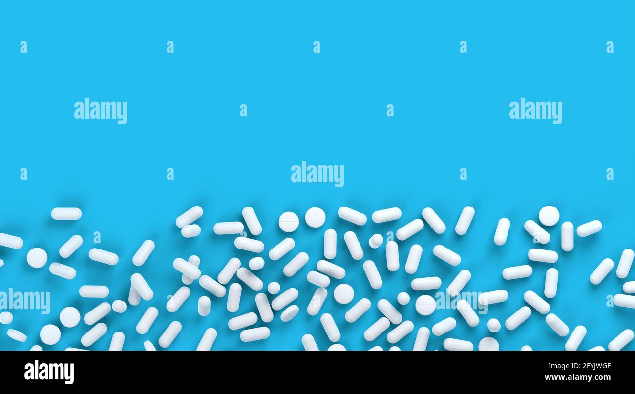 White pills border edge over blue background, medical treatment ...