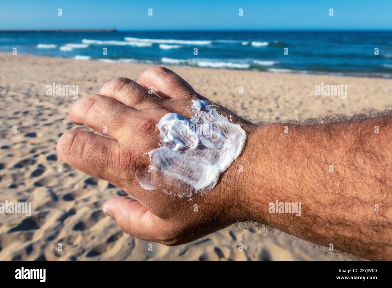 Male applying sunscreen on beach hi-res stock photography and images ...
