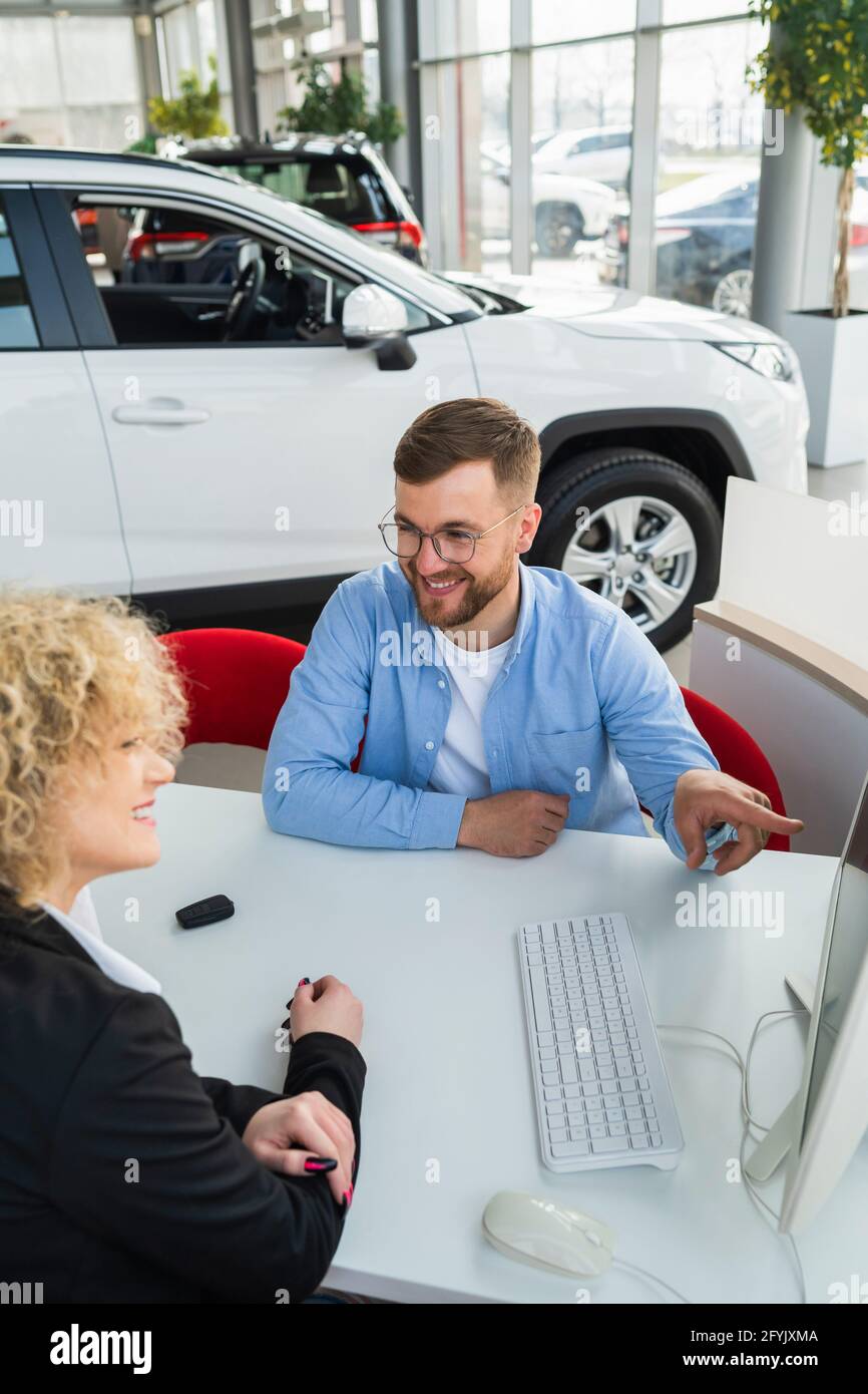 Car dealership manager with client at computer in showroom Stock Photo ...