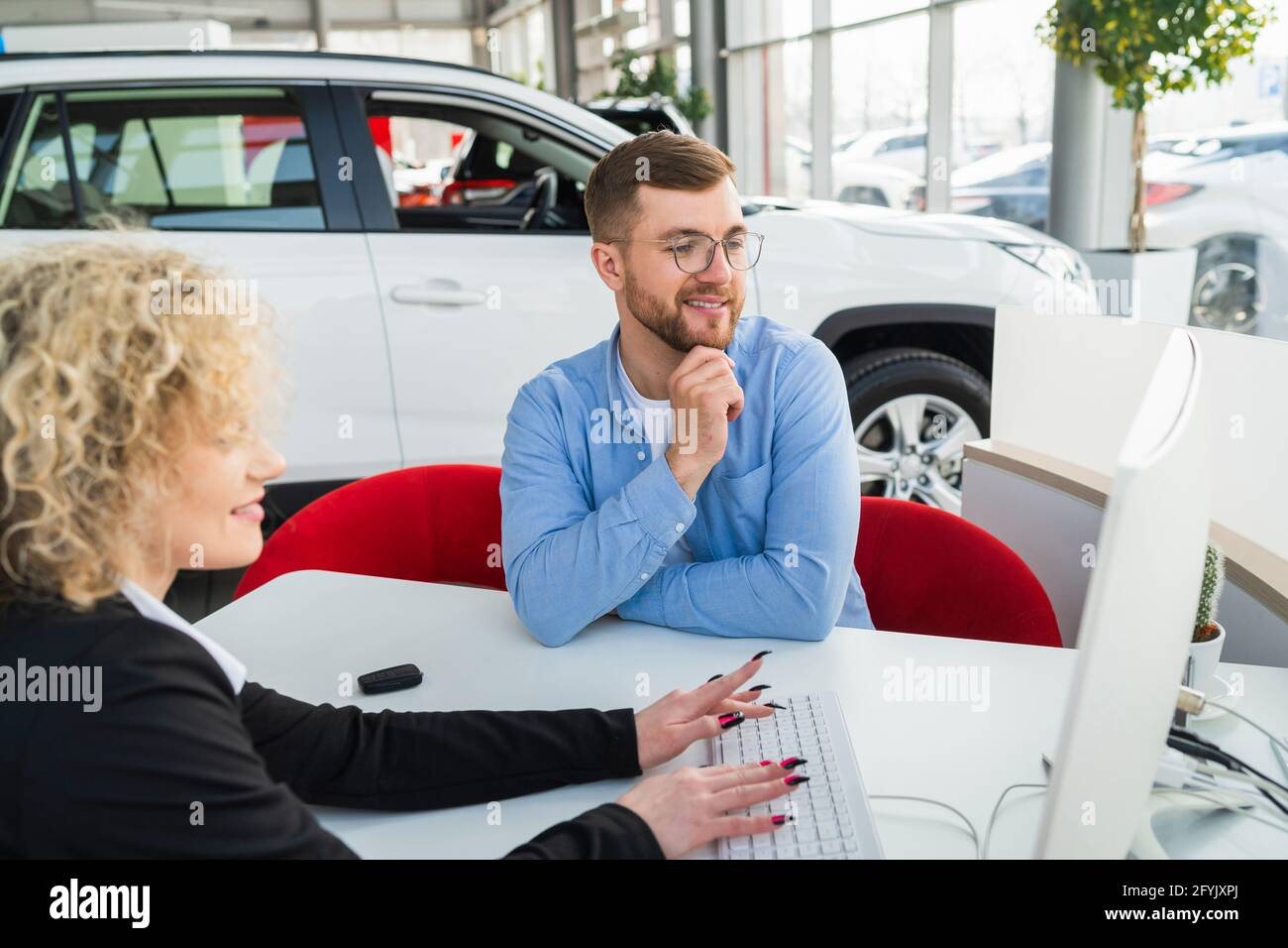 Car dealership manager with client at computer in showroom Stock Photo ...
