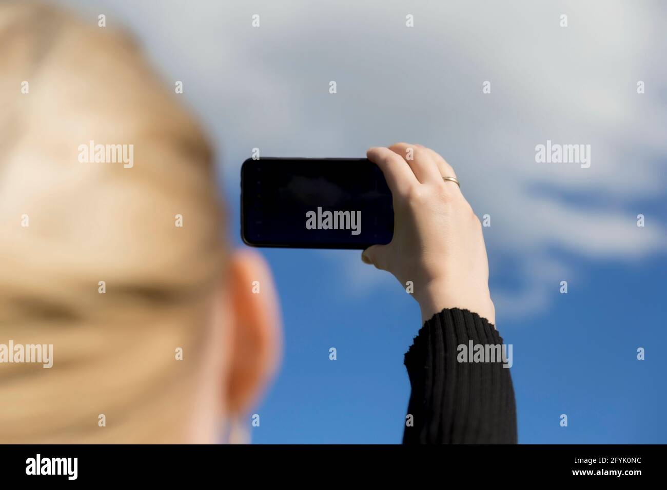 Woman photographs nature scenery on smartphone. Close up of defocused ...