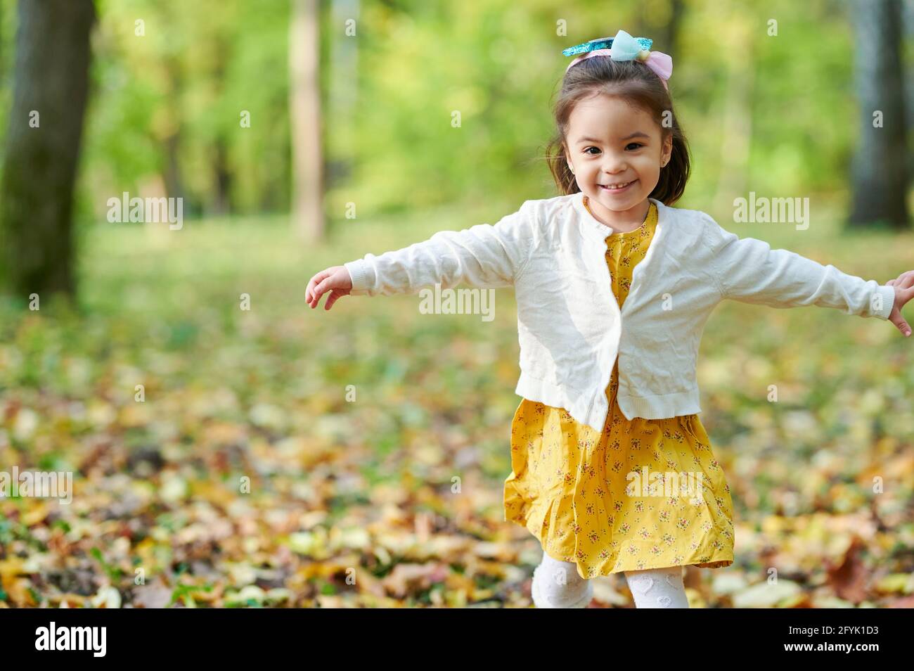 Kid run with open hands on blurred park background Stock Photo - Alamy