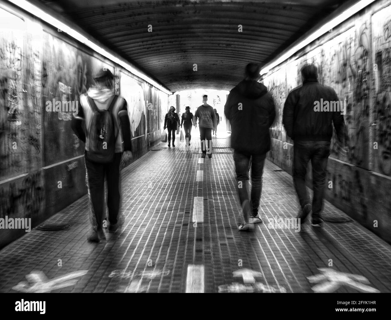 The grayscale of walking people in underground passage Stock Photo - Alamy