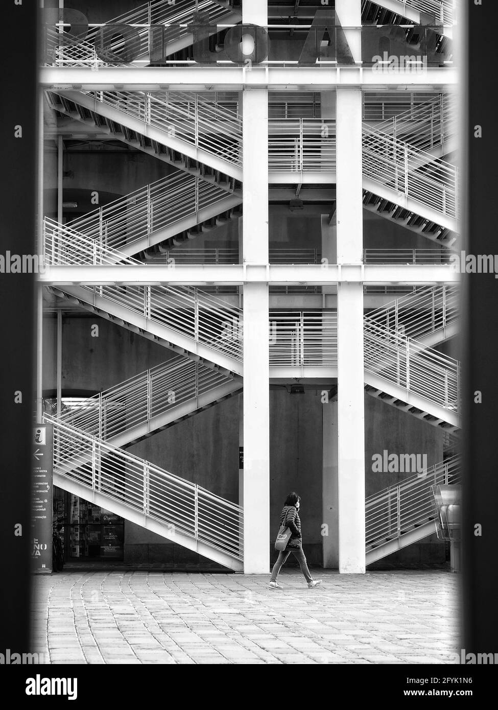 The grayscale of person passing by outside staircase Stock Photo - Alamy