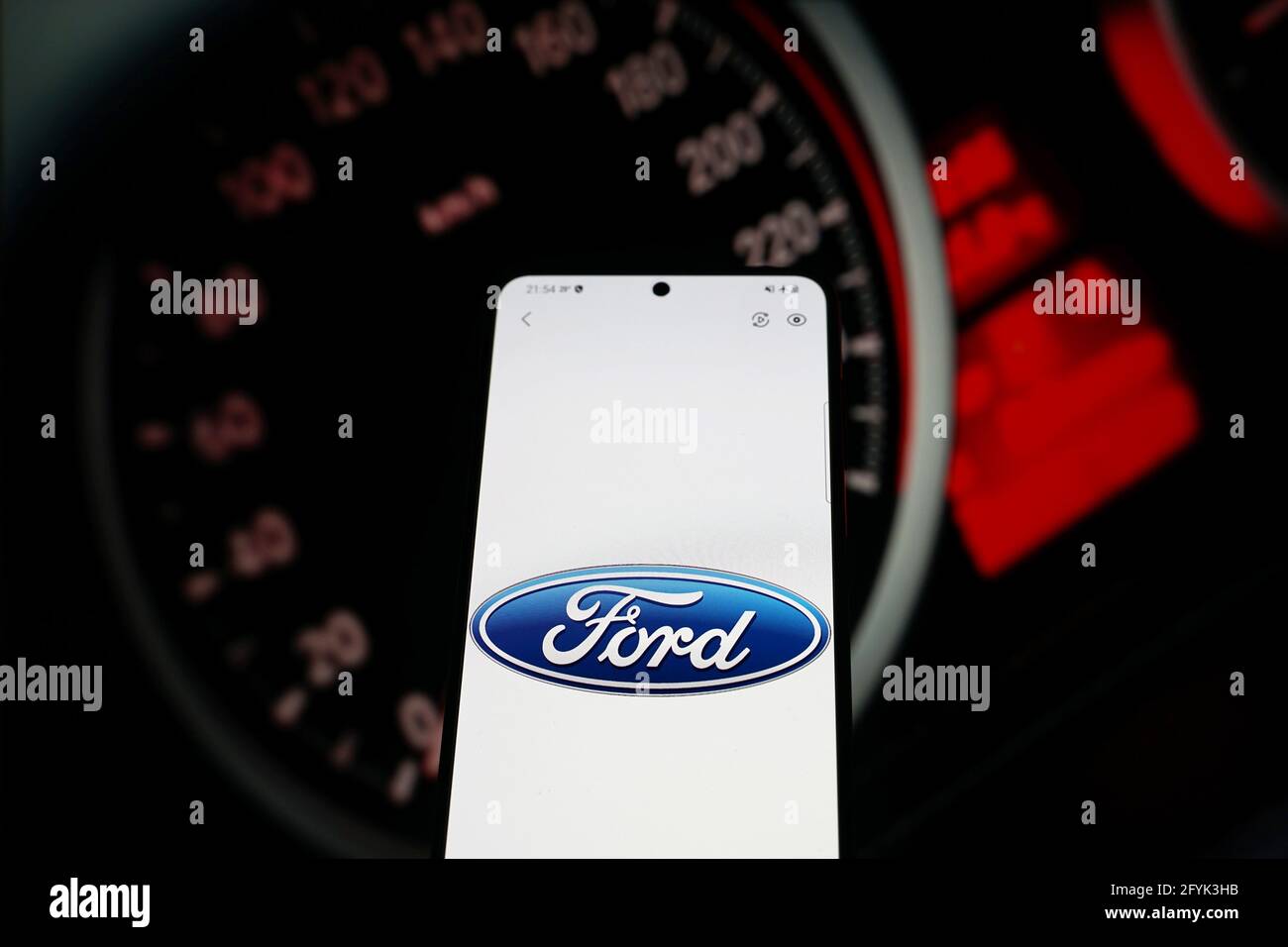 In this photo illustration a car brand logo "Ford" seen displayed on a ...