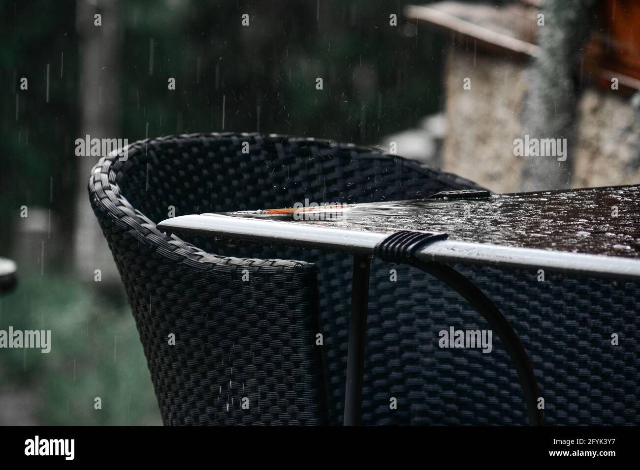 Chair and table under rain Stock Photo - Alamy