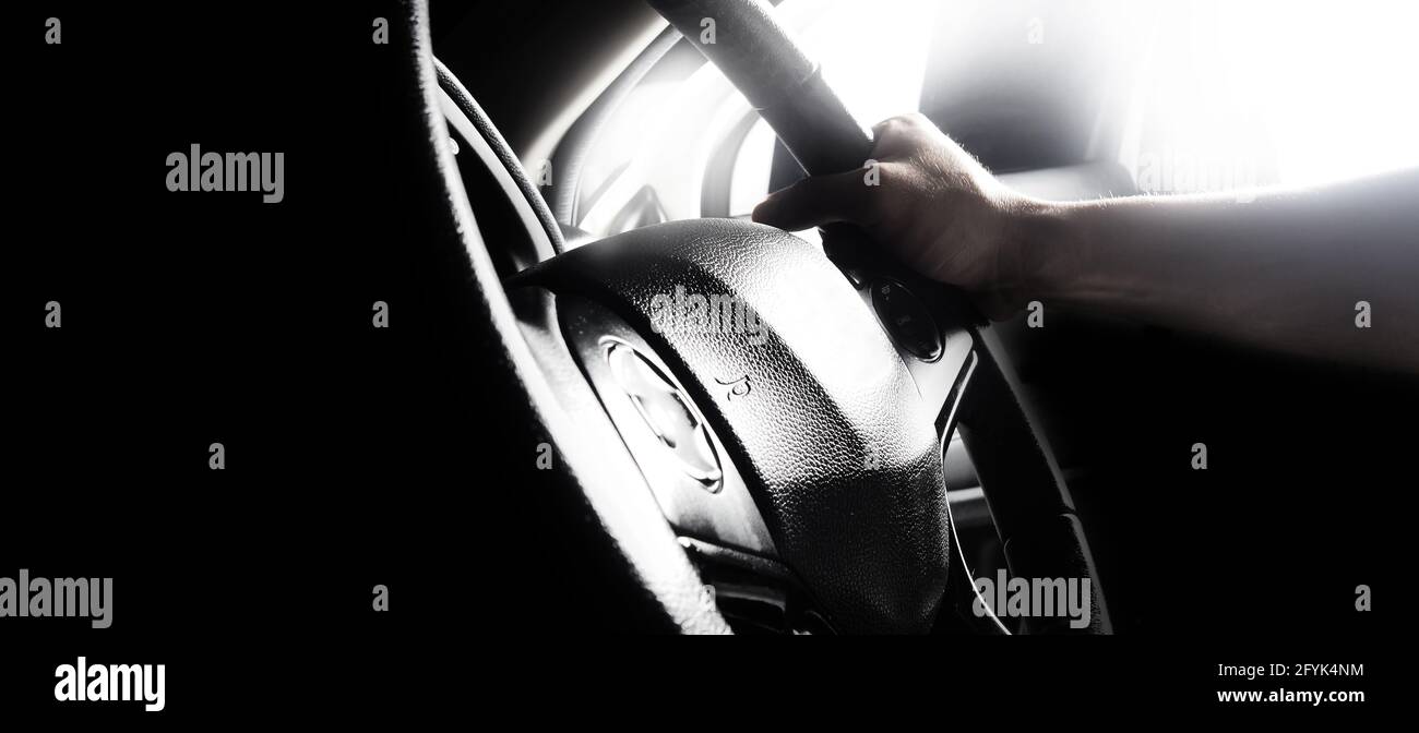 Steering wheel and man hand. Black leather modern car Interior close up ...
