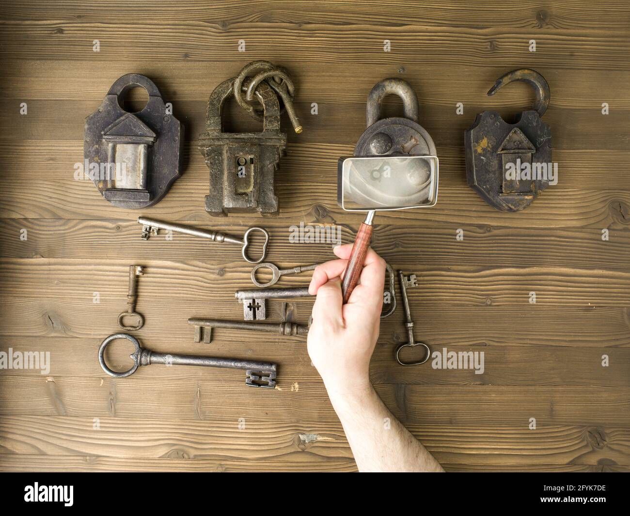 Hand holding a magnifying glass over a keyhole Stock Photo - Alamy