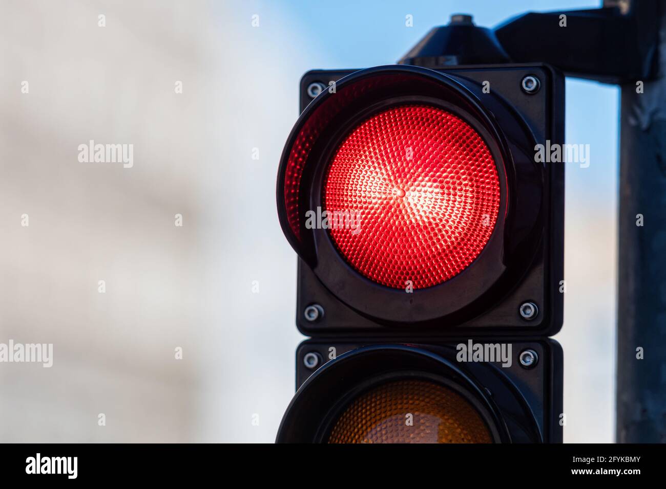 closeup of traffic semaphore with red light on defocused city street ...