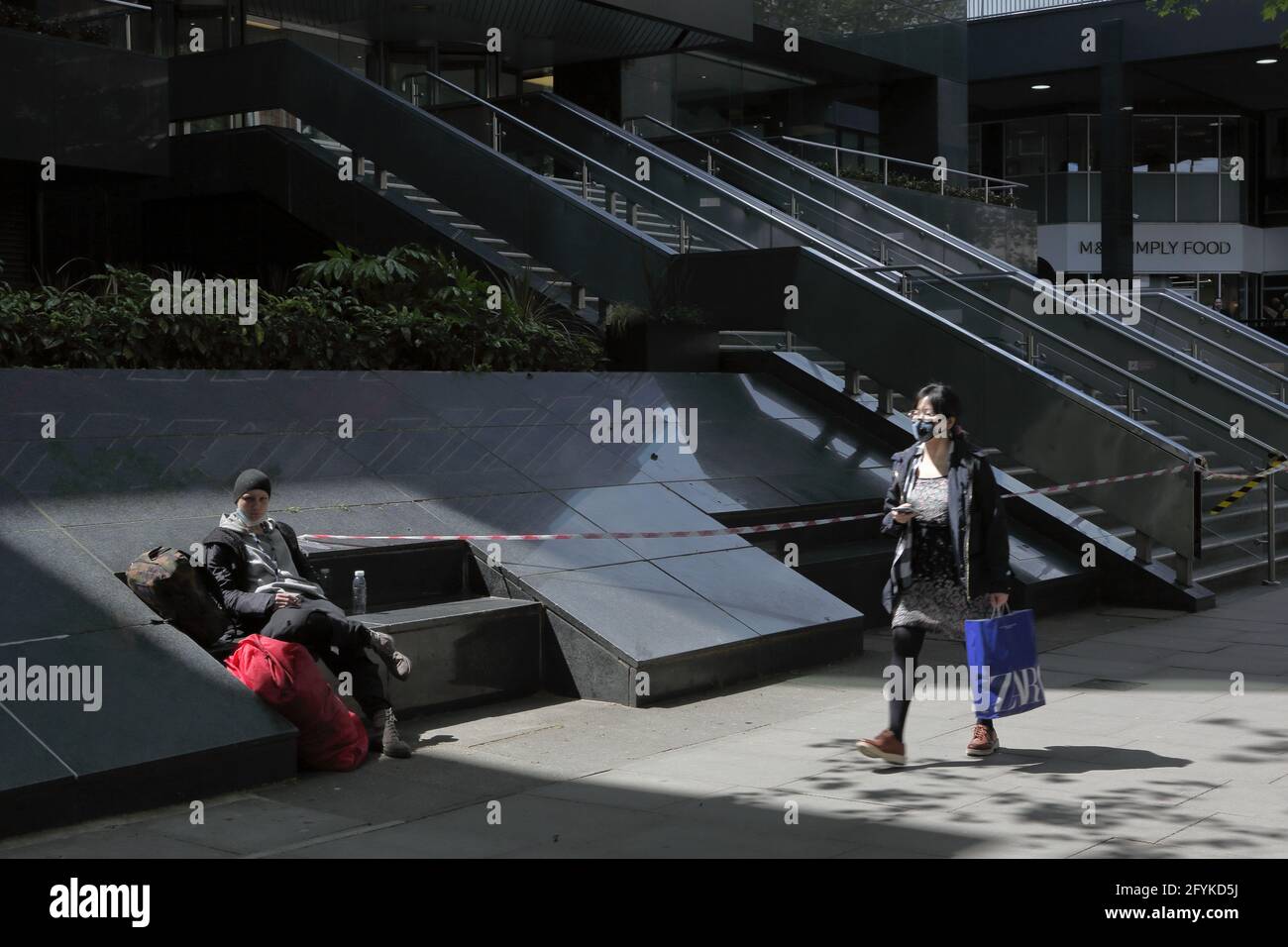London (UK): A homeless woman with backpack and sleeping bag sits in a ...