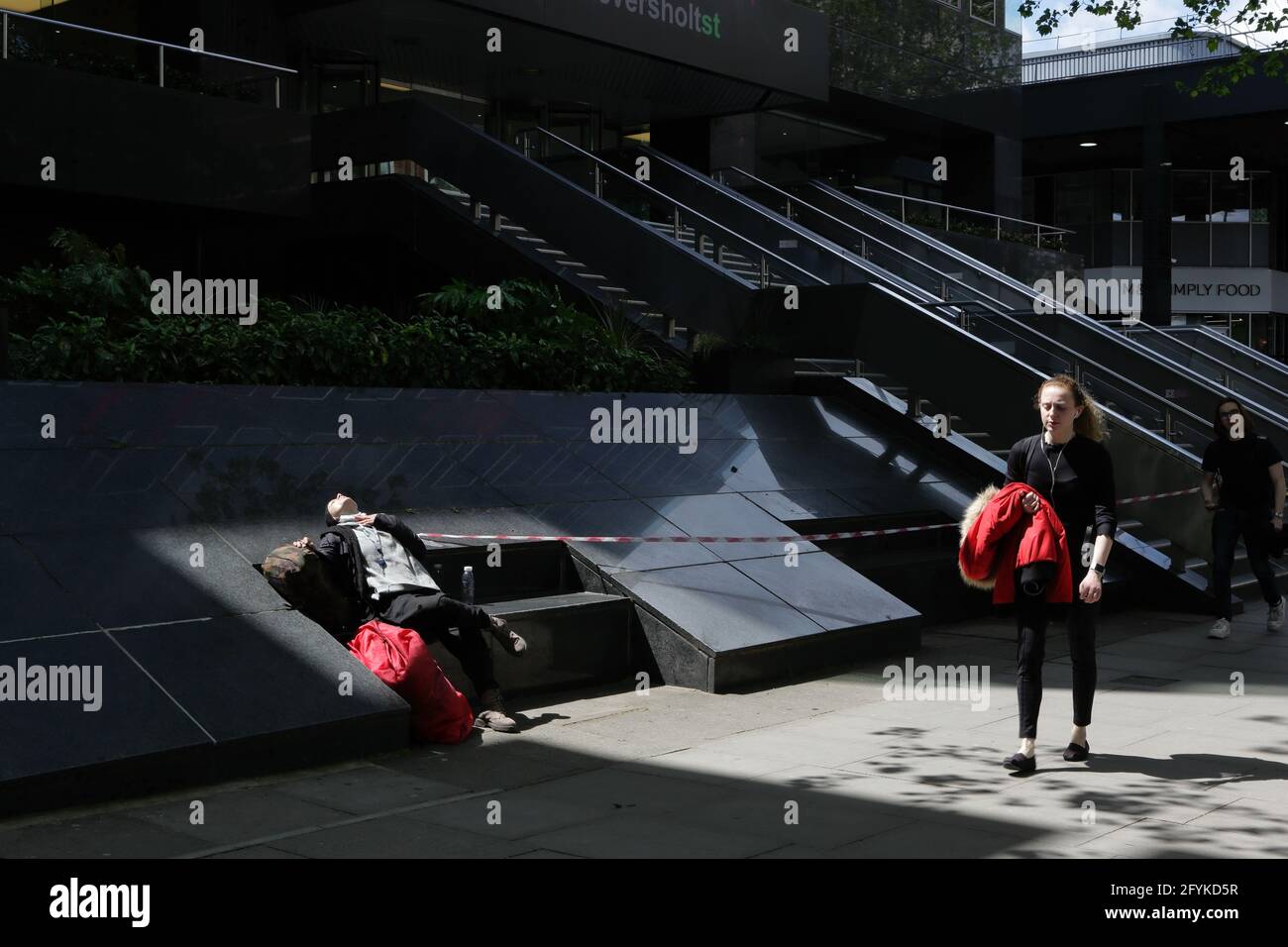 London (UK): A homeless woman with backpack and sleeping bag sits in a ...