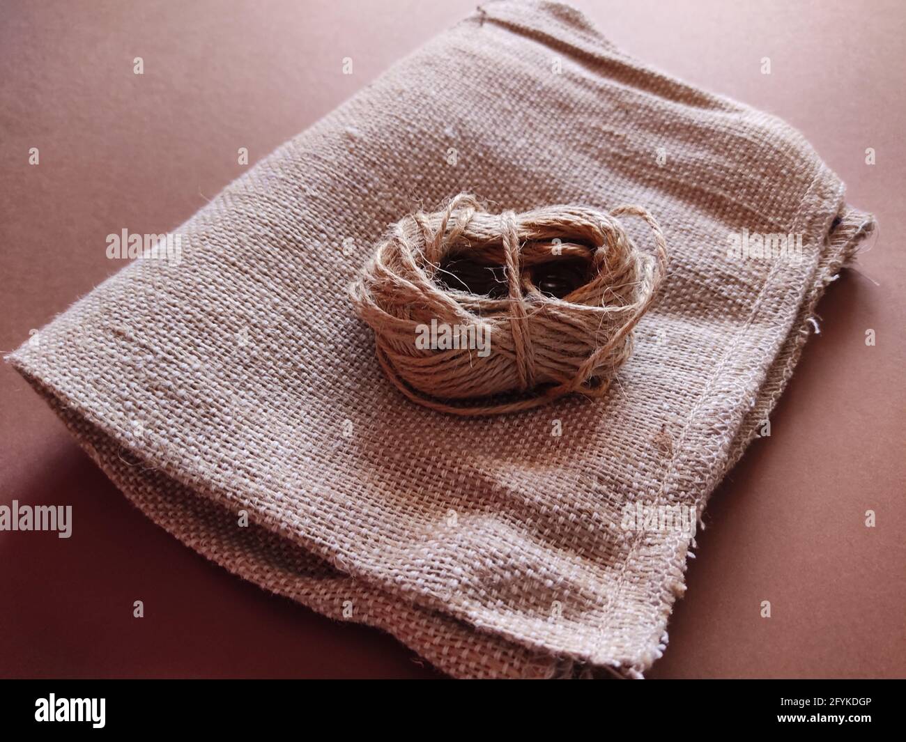 Overhead shot of a bundle and a piece of fabric on a brown surface ...