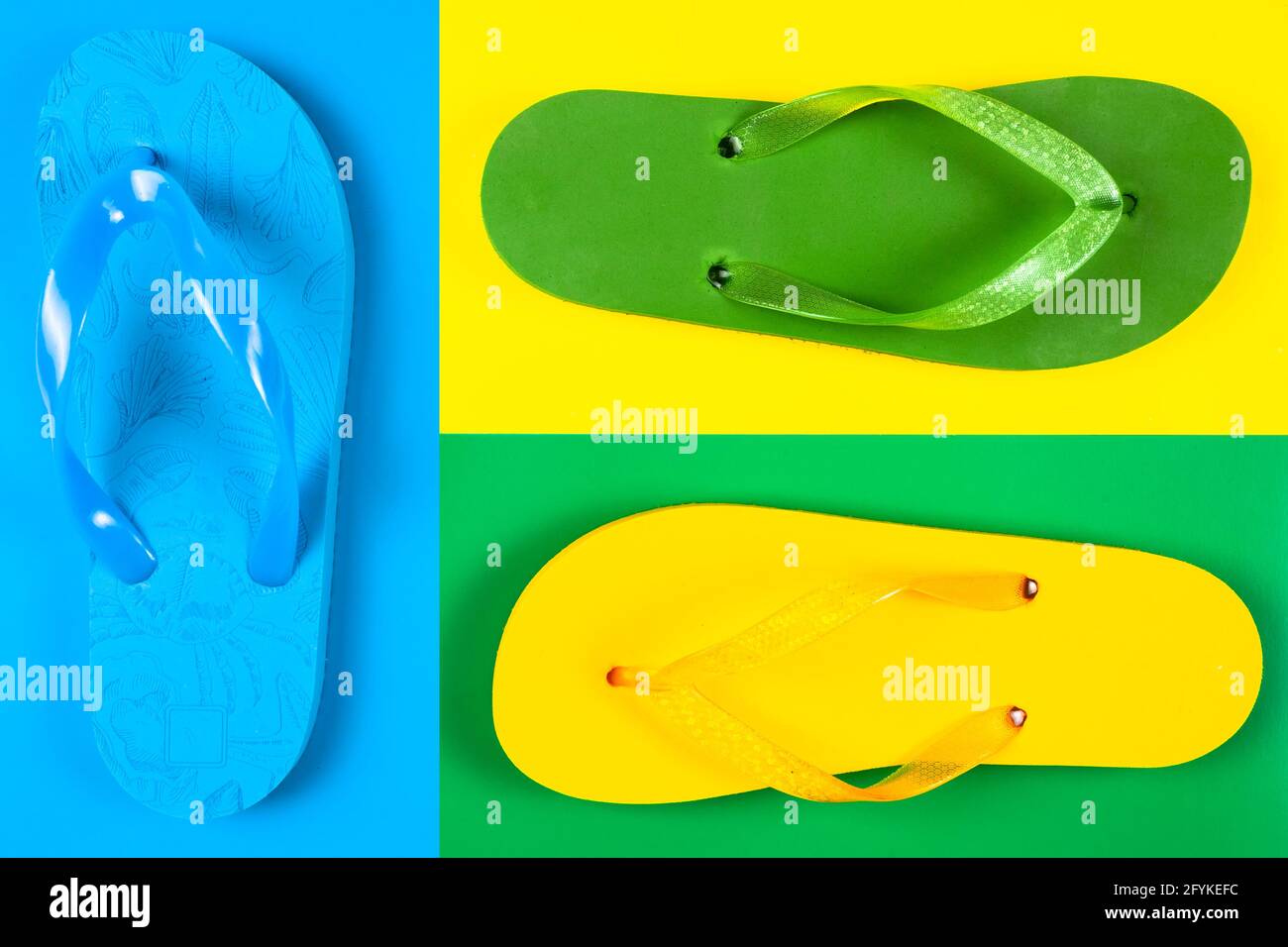 blue, yellow, green rubber flip flops on a multi-colored background ...