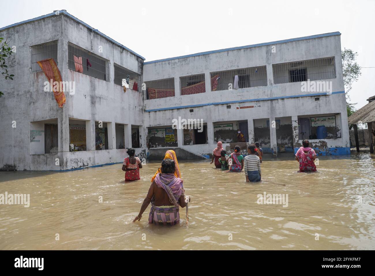 People entering a flooded school used as a cyclone centre during the ...