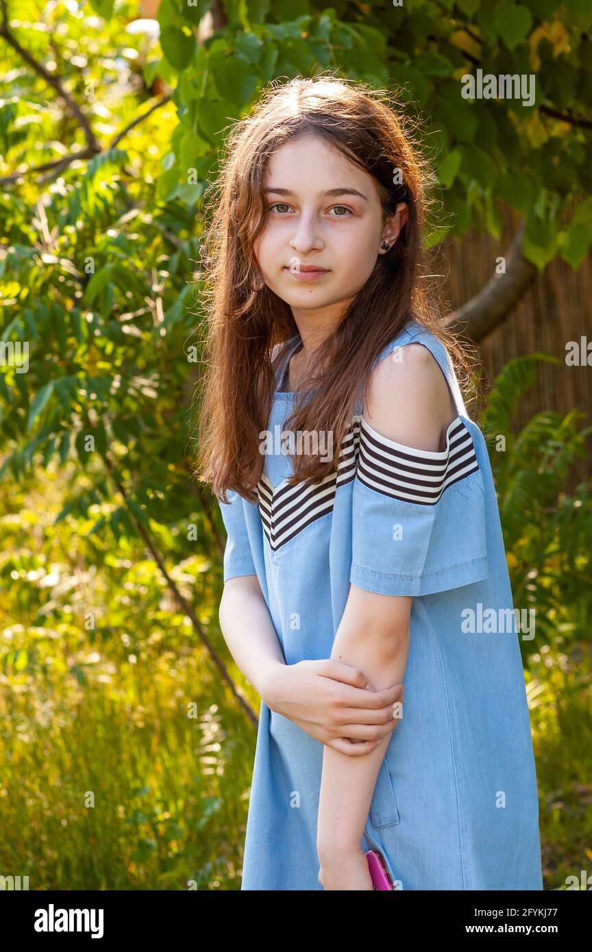 Teenager girl in nature. A school-age girl posing against a background ...