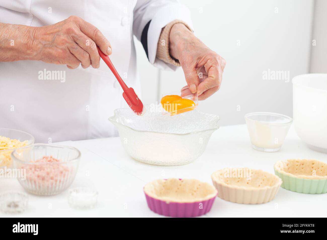 Senior woman preparing the filling for a delicious cheese and ham ...