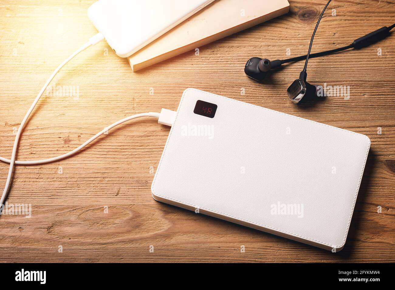 smartphone charging with white power bank. close-up at white power bank ...