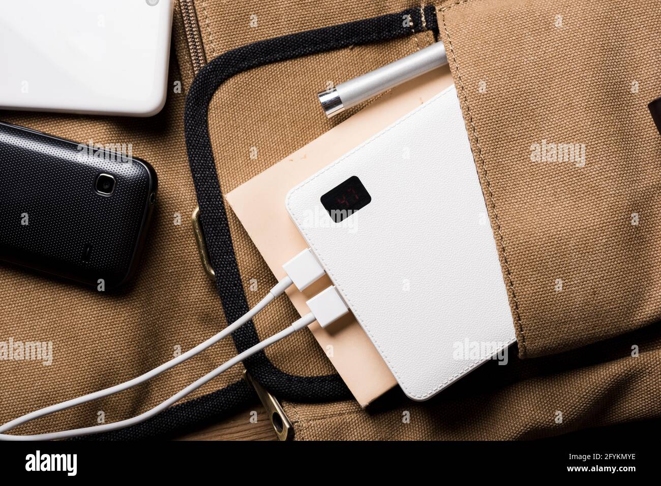 smartphone charging with white power bank. close-up at white power bank ...