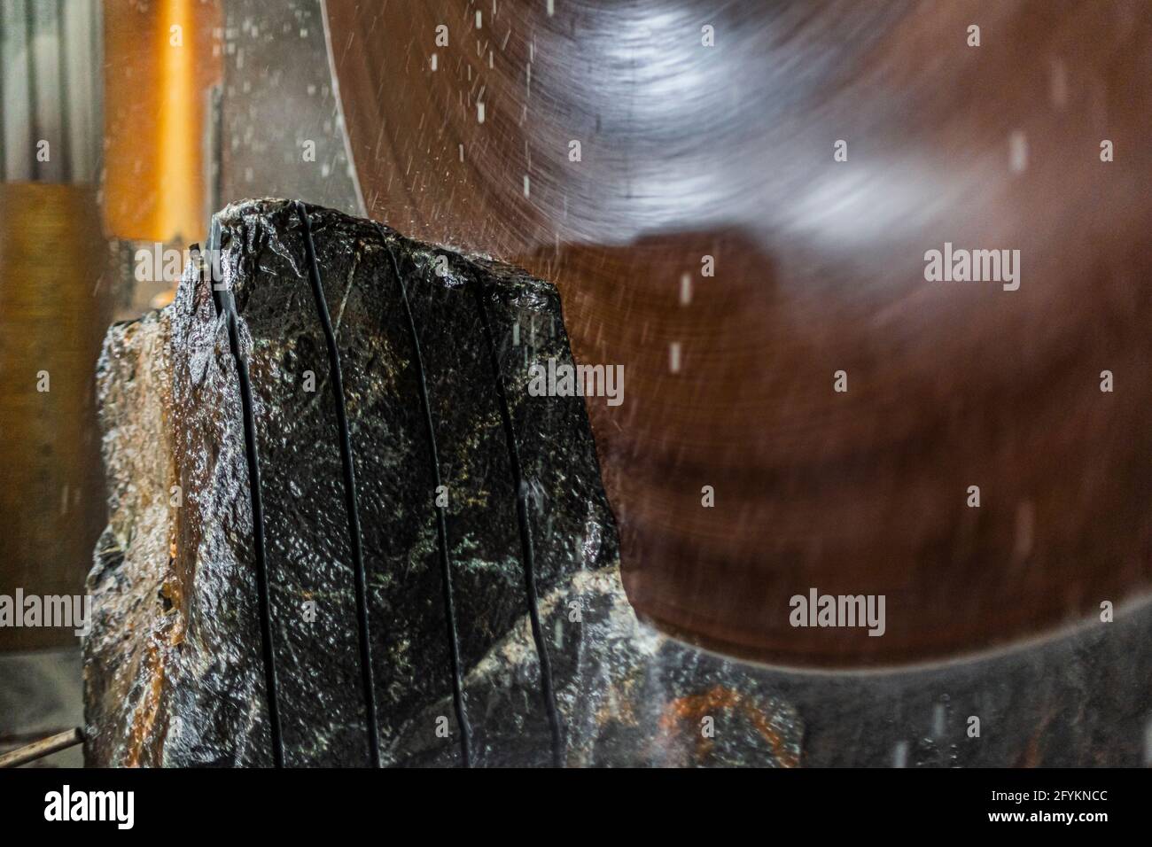 Large industrial cutting machine cuts gray granite stone into slabs ...