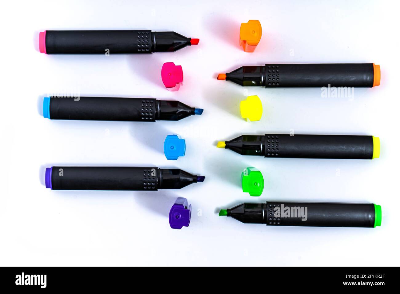 Set of uncovered color-ordered highlighters facing each other on white ...