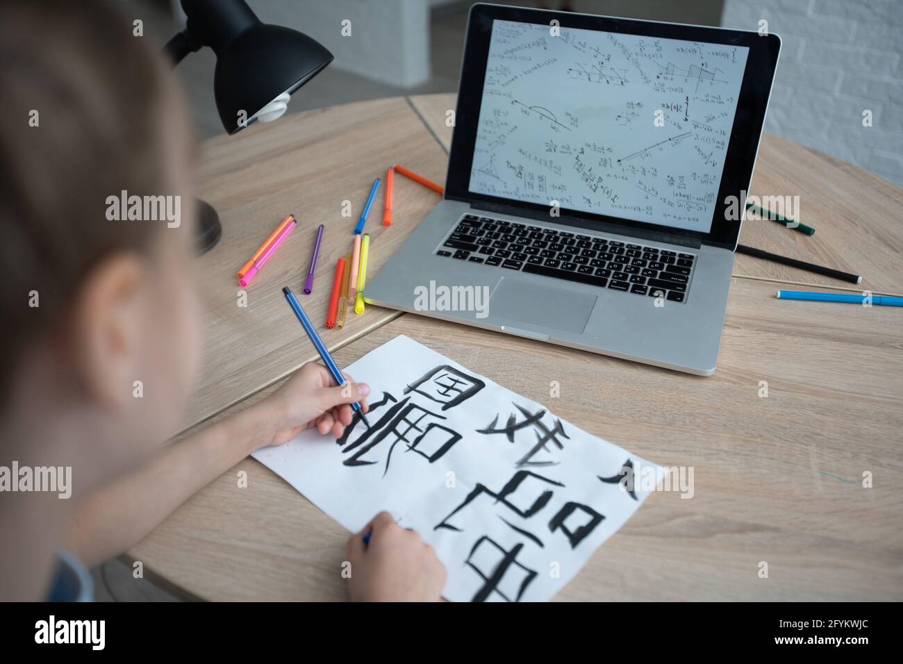 little girl learning chinese while using her laptop computer in the ...