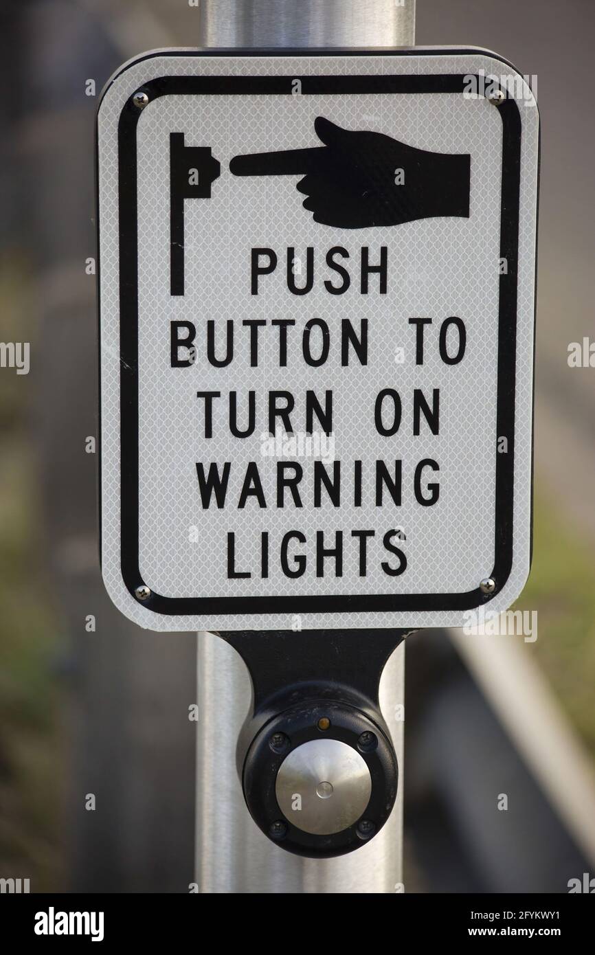 Sign saying 'push button to turn on warning lights' Stock Photo - Alamy