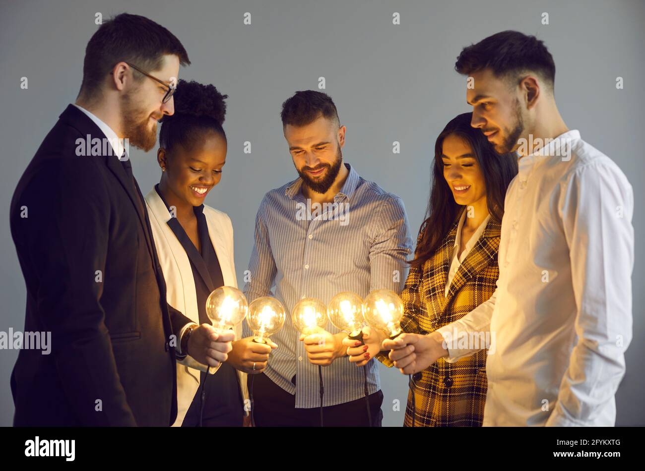 Business team holding shining light bulbs as symbol of sharing ideas in ...