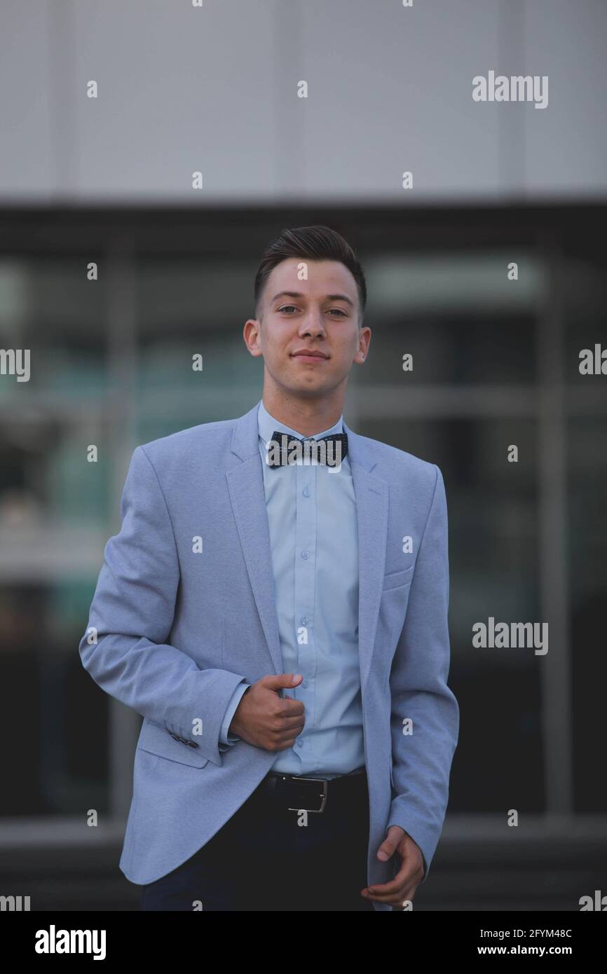 Vertical shot of a young male model posing in a light blue suit and a ...